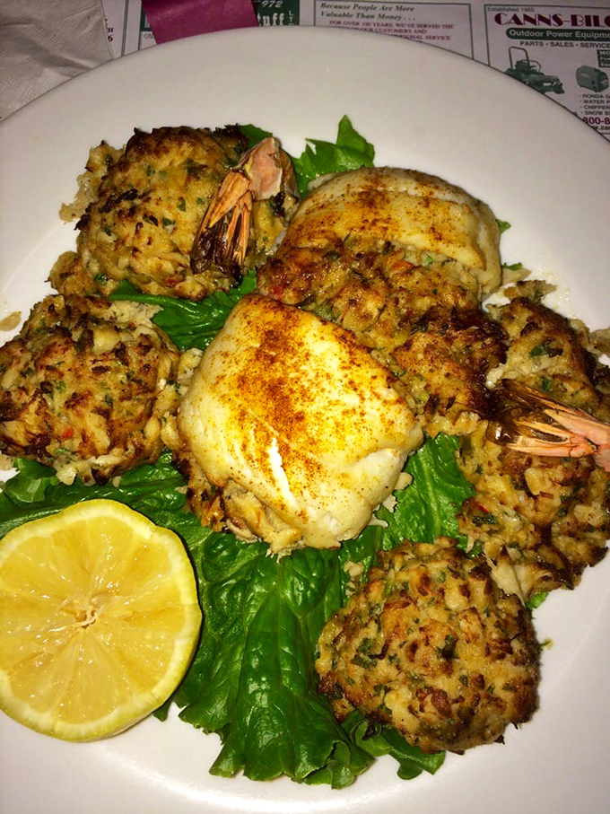 The Broiled Stuffed Trio presents seafood at its finest—a generous arrangement of crab-stuffed delicacies resting on a bed of greens with a squeeze of brightness.