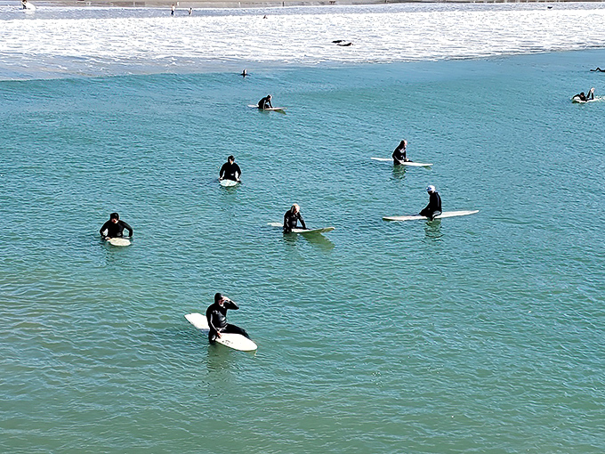 Wetsuit-clad surfers patiently await their moment with the perfect wave, a timeless California ritual performed daily in Cayucos waters.