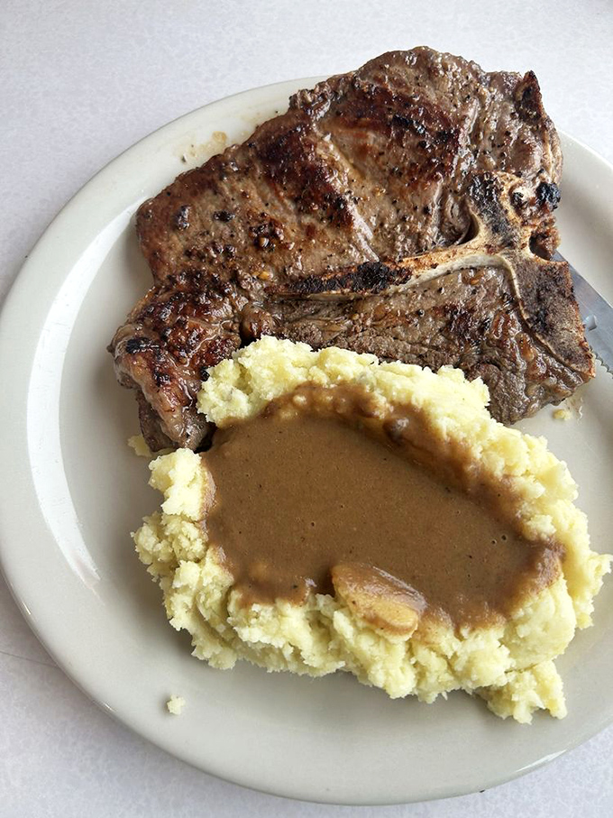 A T-bone steak with mashed potatoes and gravy&mdash;the kind of plate that makes vegetarians briefly question their life choices.