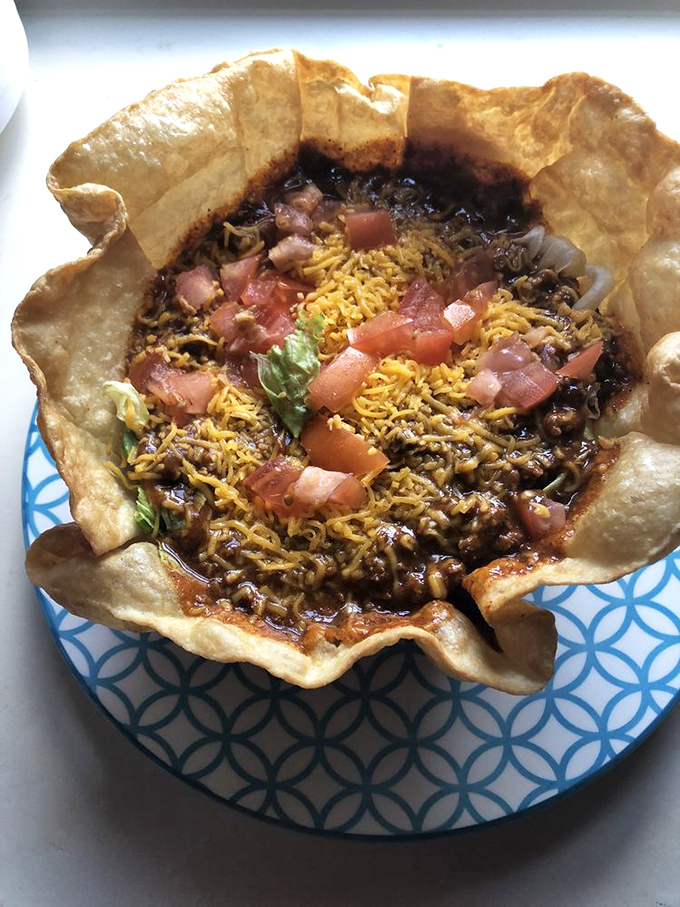 Not just a taco salad, but a crispy edible bowl of joy where beef, cheese, and fresh vegetables come together like the world's most delicious architectural achievement.