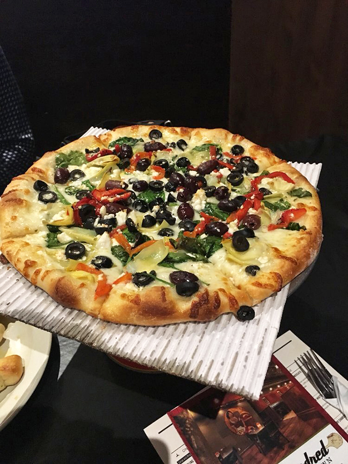 The Leonidas pizza showcases a vegetable rainbow that makes eating your greens feel like discovering buried treasure.