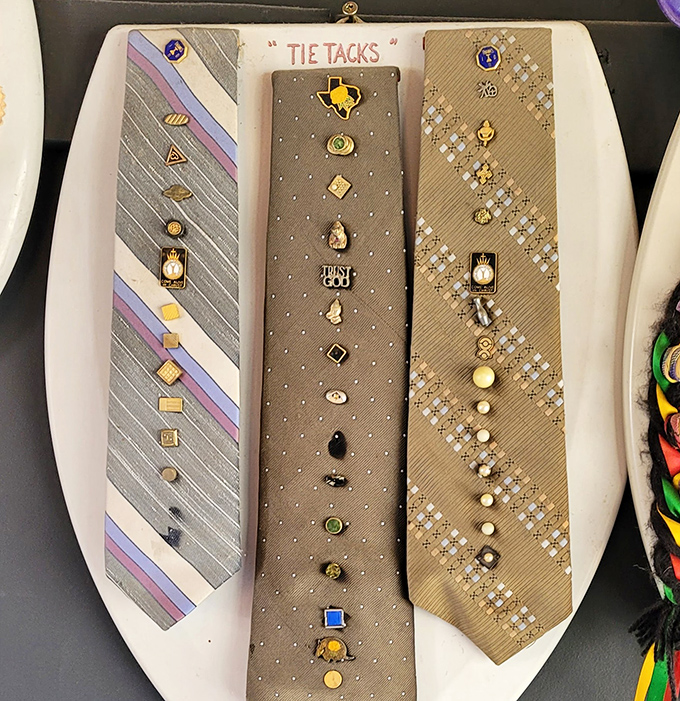 "Tie Tacks" displays an impressive collection of miniature pins arranged on necktie-shaped backgrounds. Someone's dad collection has found its forever home.