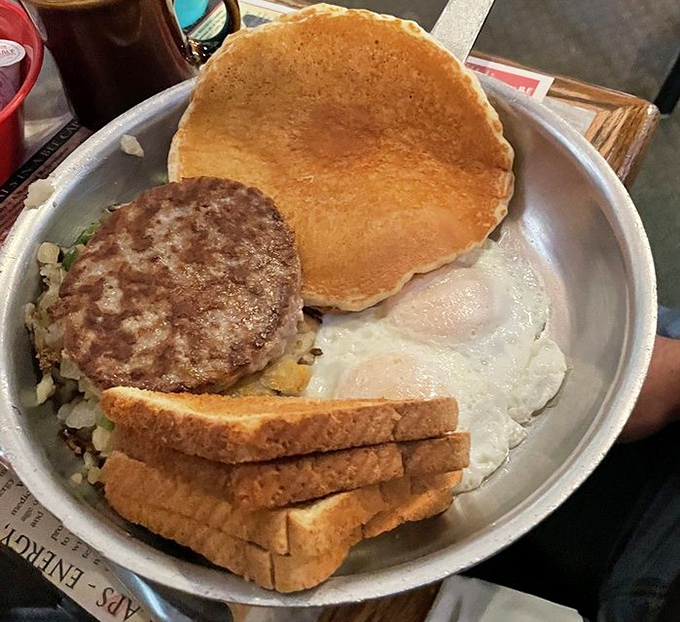The metal platter barely contains this breakfast bounty &ndash; eggs, pancake, sausage patty, and toast creating a morning quartet that sings in perfect harmony.