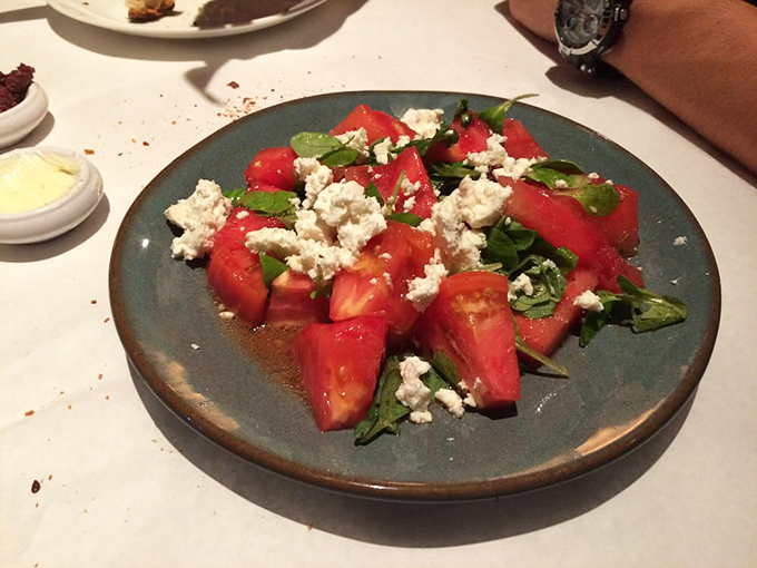 A tomato salad that reminds you why summer exists. Simple ingredients performing a complex symphony on your taste buds.
