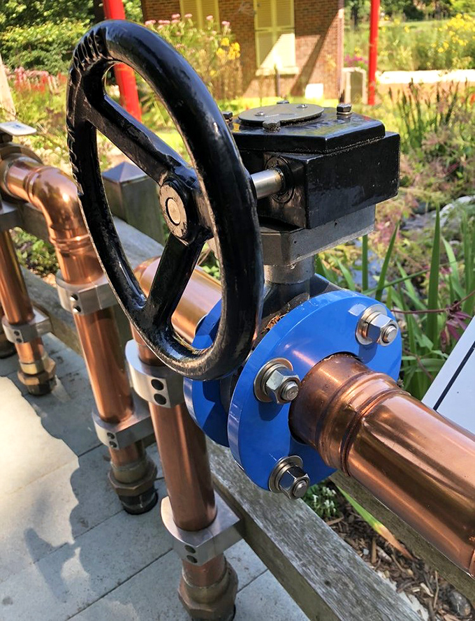 Industrial art meets garden function with this vintage valve wheel&mdash;a reminder that beneath Wellfield's beauty lies the practical purpose of water management. 