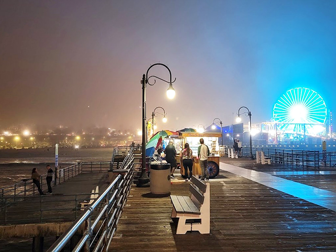 Twilight transforms the boardwalk into a moody cinematic scene, where strangers become silhouettes against the glow of seaside magic.