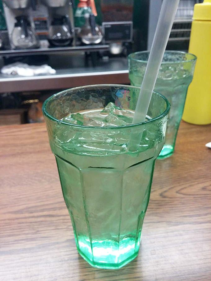 Those distinctive green glasses aren't just containers—they're a promise that simple pleasures like ice-cold water still matter in a complicated world.