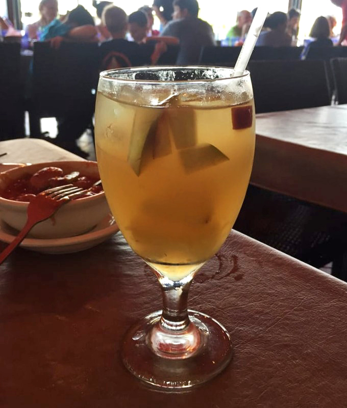 White sangria that looks dangerously refreshing. The kind of drink that makes you say "just one more" until the sun suddenly sets.