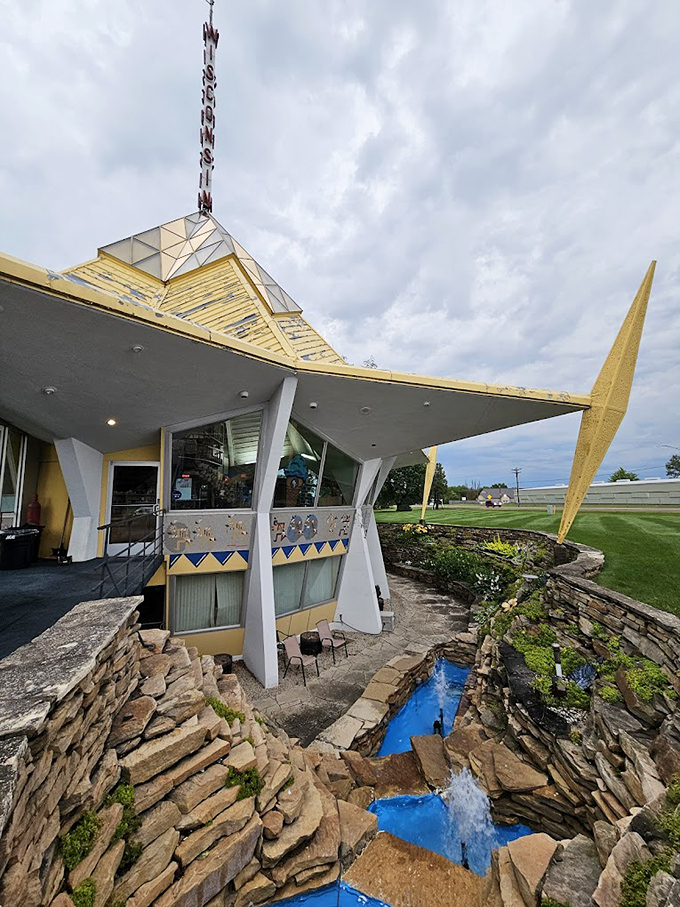 The pavilion's stone waterfall feature adds a touch of natural elegance to this architectural time capsule from another era.