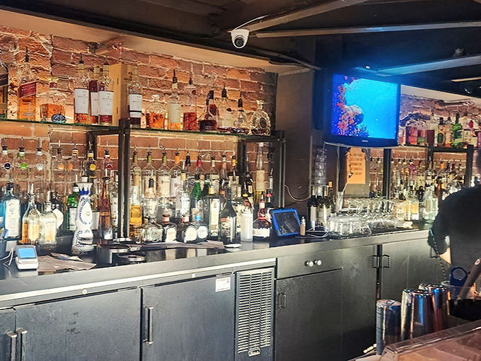 Behind the bar, bottles gleam like sunken treasure while the blue glow from above casts an otherworldly spell.