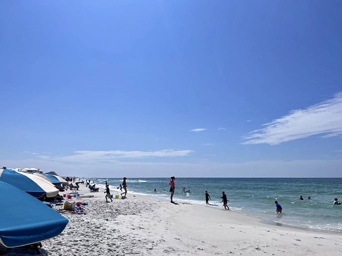 Summer's universal language: children splashing in waves, adults soaking up sun, and everyone forgetting what day of the week it is.