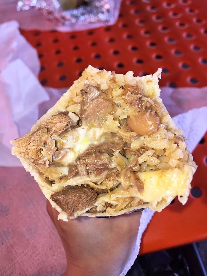 Cut in half to reveal its secrets—this beef burrito shows off its perfect rice-to-meat ratio like a culinary cross-section of heaven.