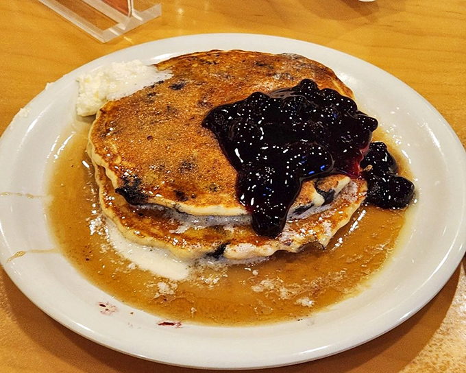 Blueberry pancakes swimming in syrup and topped with fruit compote &ndash; breakfast elevated from mere sustenance to morning celebration.