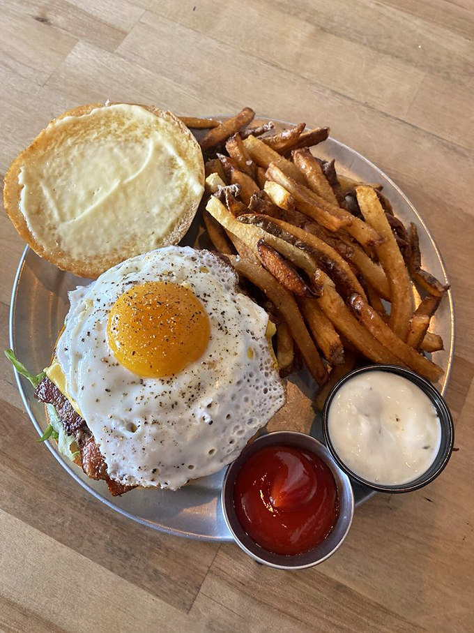 Breakfast meets burger in holy matrimony. That sunny-side-up egg looks like it's about to baptize the patty below in golden yolk salvation.