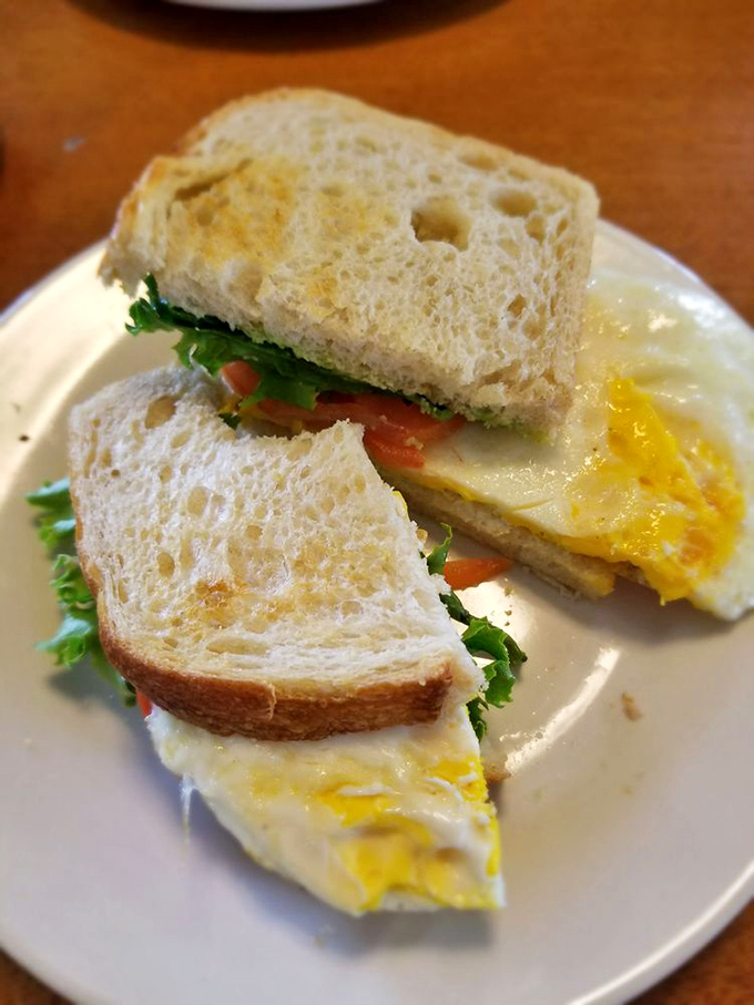 This breakfast sandwich towers like a delicious skyscraper, proving that good things come to those who order wisely.