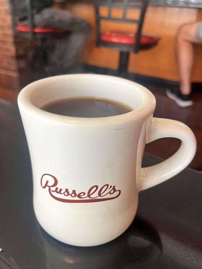 The sturdy white mug emblazoned with "Russell's" isn't just holding coffee&mdash;it's holding liquid motivation for your entire day.