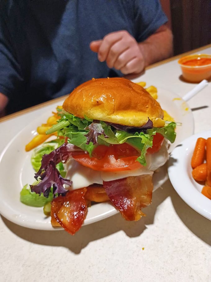 A burger built like a skyscraper of flavor&mdash;bacon, cheese, fresh vegetables, and a bun that somehow manages to contain this beautiful chaos.
