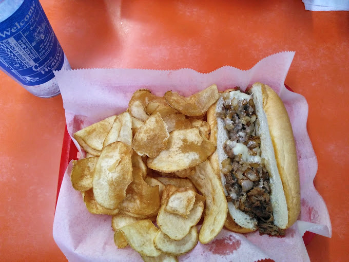 A cheesesteak that doesn't need Philadelphia's permission – tender meat, melted cheese, and house-made chips that crunch like autumn leaves.