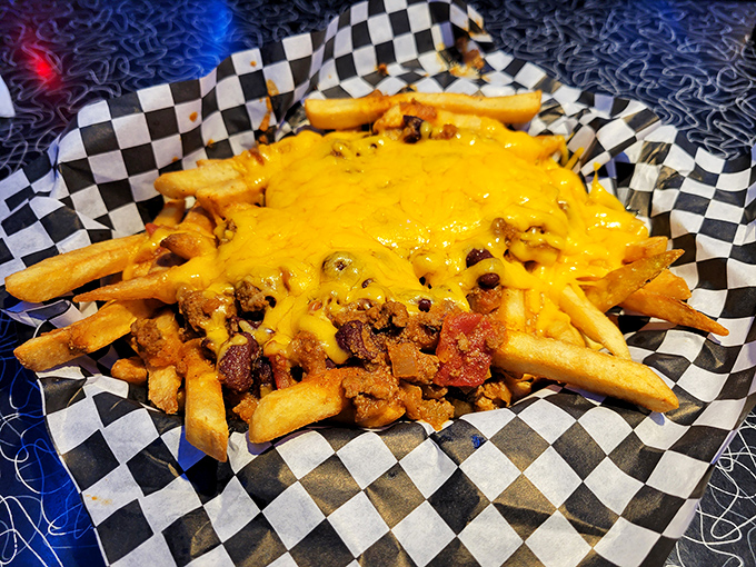 Chili cheese fries served in a checkered basket—where molten cheese creates the perfect lava flow over crispy fries and savory chili. Diet starts tomorrow!