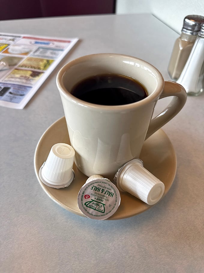 The sturdy diner mug cradles coffee dark enough to see your future in, with cream companions waiting patiently for their grand entrance.