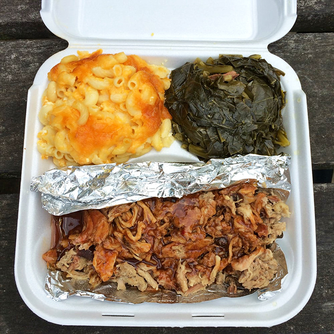 The complete barbecue experience: pulled pork, mac and cheese, and collard greens. A holy trinity of Southern comfort on a humble foam plate.
