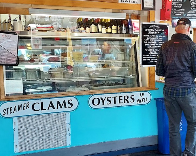 At the counter, the turquoise "STEAMER CLAMS" and "OYSTERS IN SHELL" signs aren't just information&mdash;they're promises of briny delights to come.