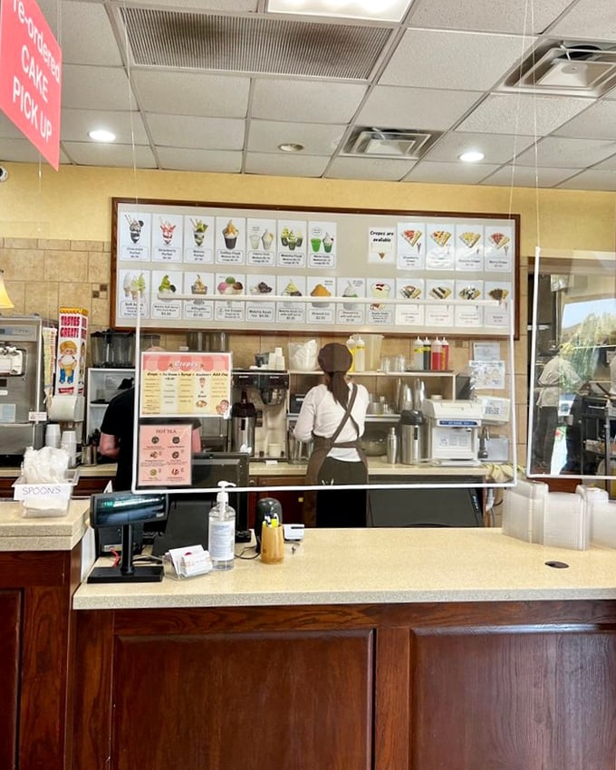 Behind this counter, culinary magic happens daily. The menu board showcases an impressive array of crepe options that would make even a Parisian nod in approval.