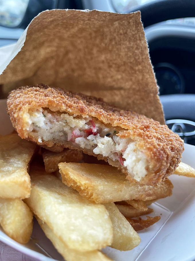 That perfect cross-section reveals a crab cake that's actually about the crab, not about how much filler can be hidden beneath a crispy exterior.