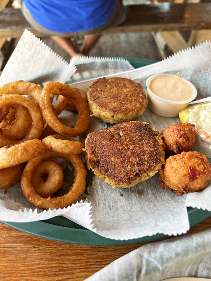 Crab cakes and onion rings: the dynamic duo of seafood dining. Crispy exteriors giving way to tender interiors&mdash;it's textural poetry on a plate.