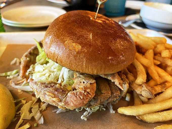 This towering soft shell crab sandwich is the architectural marvel of the seafood world, crispy legs peeking out beneath a glossy brioche crown.