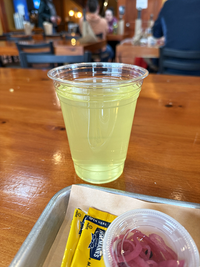 Even the simplest drink becomes part of the experience here, where pickled onions wait patiently to complement your smoky feast.