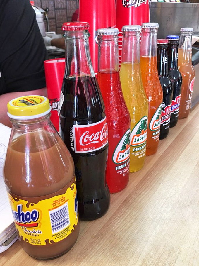 A lineup of colorful sodas in glass bottles &ndash; because sometimes the perfect hot dog companion comes with a satisfying "pop" when opened.