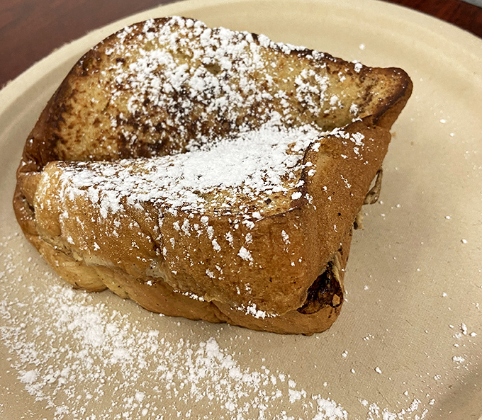 French toast that's achieved that mythical balance: crispy edges, custardy center, and just enough powdered sugar to make you feel like you're getting away with something.