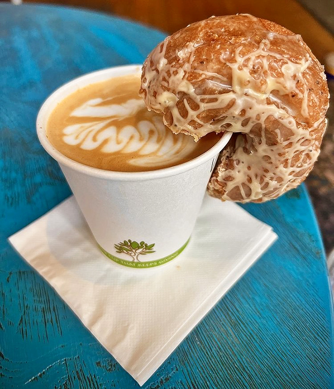 Coffee and pastry, the Fred Astaire and Ginger Rogers of breakfast&mdash;elegant latte art dancing beneath a glazed donut perched on the cup's edge.