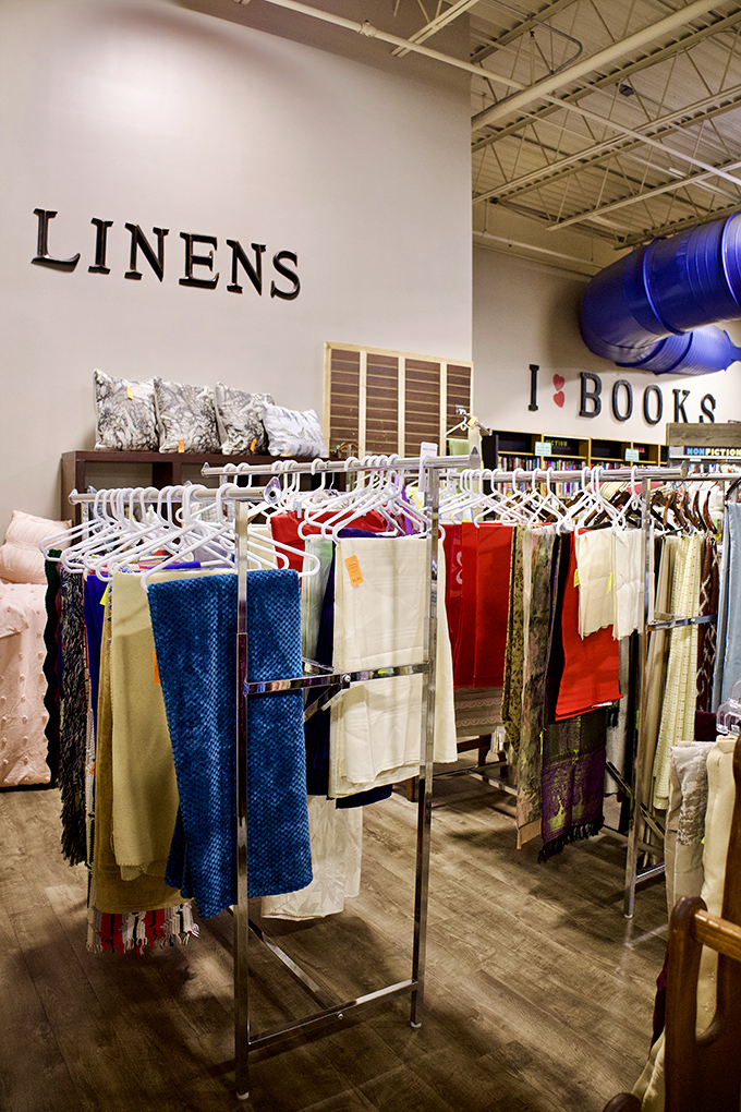 The linens department stands adjacent to books, proving that both bedding and reading material are essential ingredients for a cozy night in.