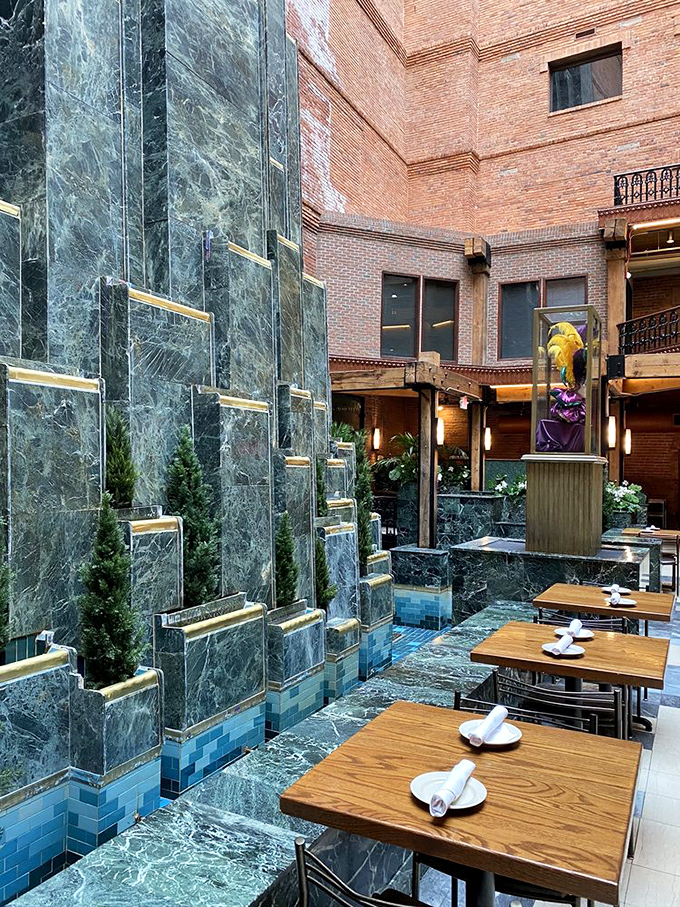 An elegant courtyard oasis with marble waterfall and wooden tables. Urban dining elevated to art form in this unexpected Greektown retreat.