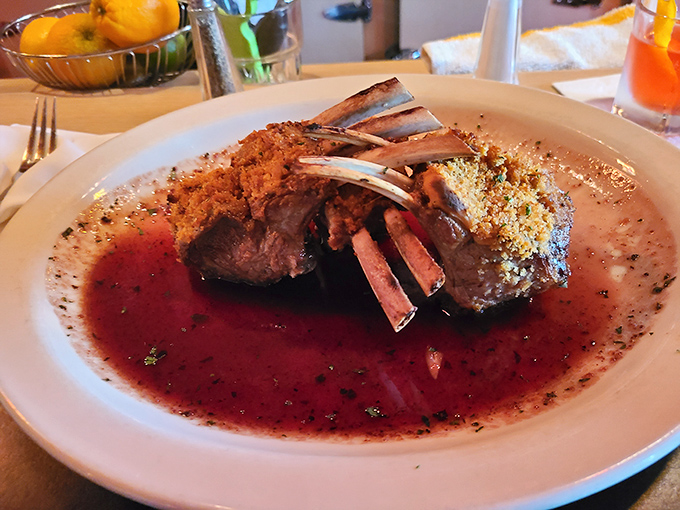 The rack of lamb stands proud like a meaty crown, glistening in its savory reduction. Those exposed bones aren't just for show&mdash;they're handles for the civilized carnivore.