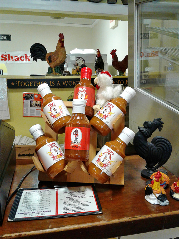 Their signature sauces displayed like liquid treasure, surrounded by chicken figurines standing guard&mdash;because flavor this good needs protection.