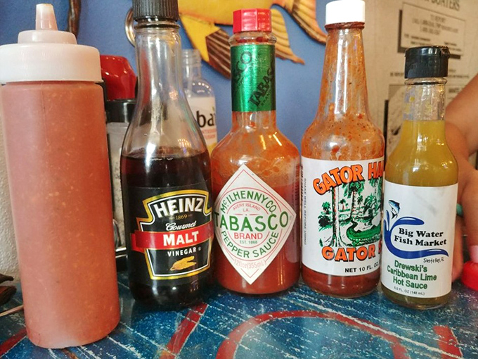 The condiment lineup&mdash;where culinary magic begins. From classic Tabasco to their house-made Drewski's Lime Hot Sauce, each bottle promises to elevate your seafood experience.