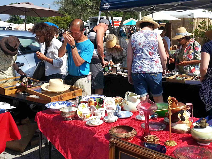 Serious collectors huddle around tables of porcelain treasures, each teacup and saucer a portal to afternoon teas of bygone eras.