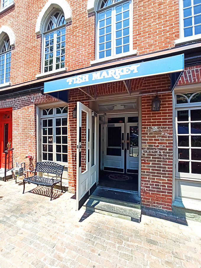 The Fish Market's historic brick facade whispers of Old Town Alexandria's charm. That blue awning marks the spot for seafood excellence.