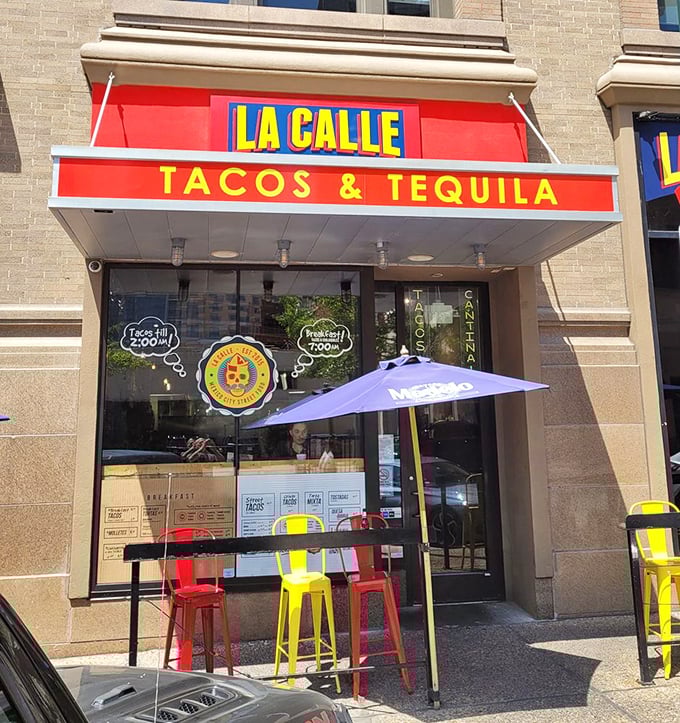 La Calle's bright red awning and cheerful outdoor seating create the perfect urban taco oasis. Those colorful stools are calling your name!