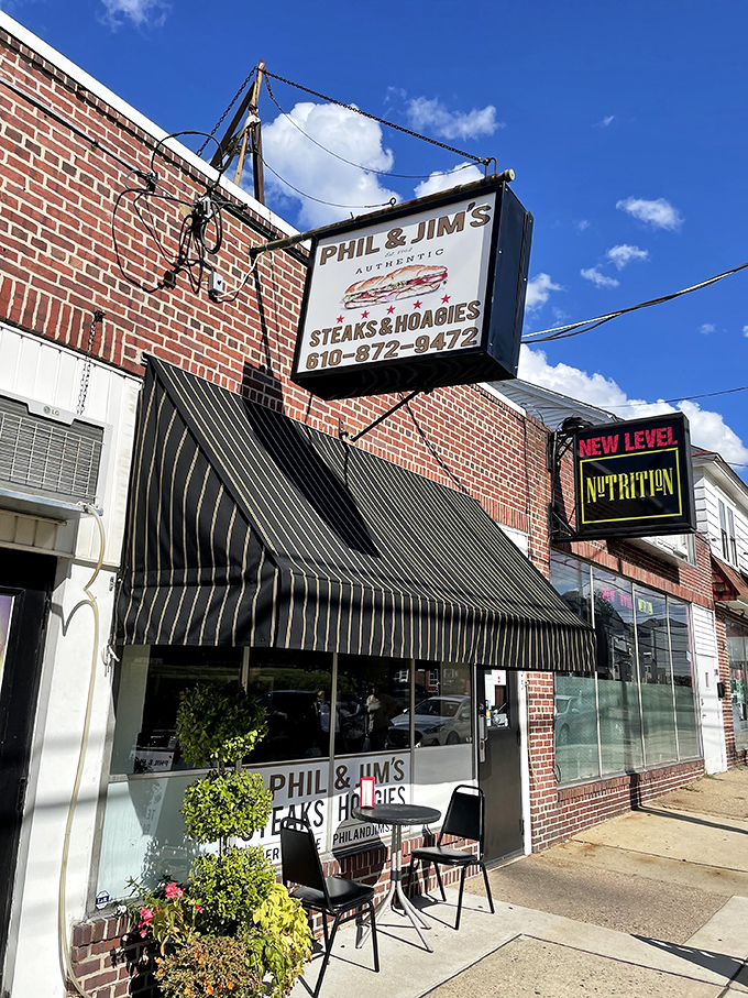 Phil & Jim's hanging sign has been pointing the way to cheesesteak happiness for 60 years. That black awning means serious sandwich business.