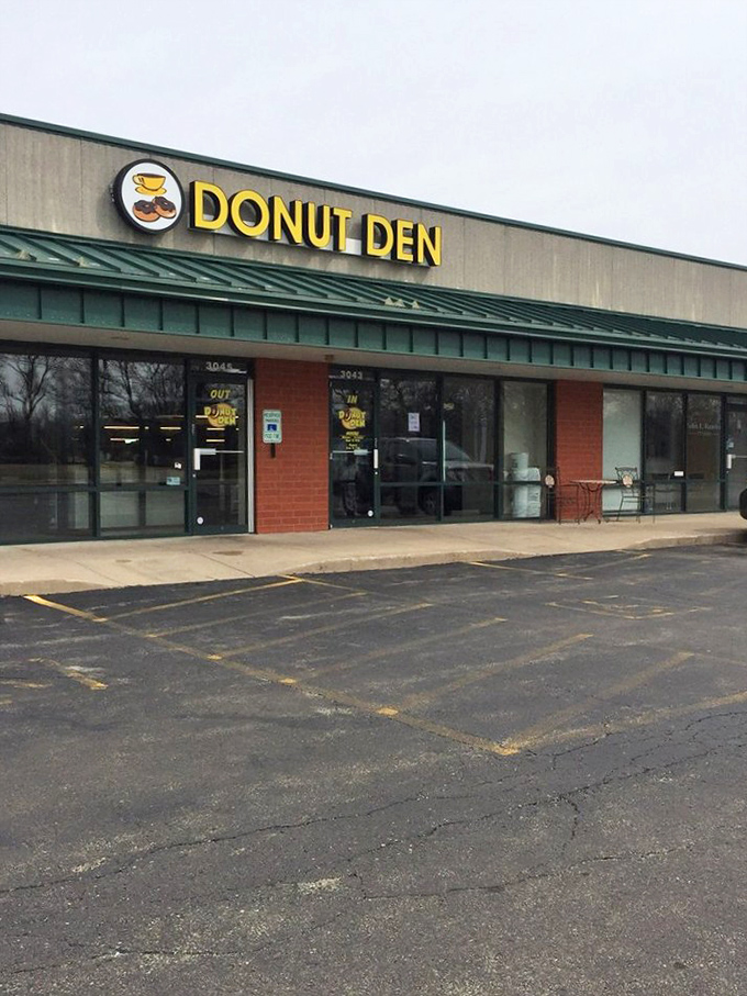 The Donut Den sign glows like a beacon for the breakfast-hungry. Where donut dreams come true without any unnecessary fuss.