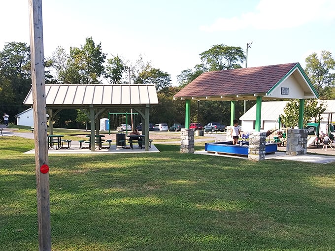 Open spaces designed for gathering, not just passing through&mdash;where community happens naturally under simple shelters that serve without pretension.