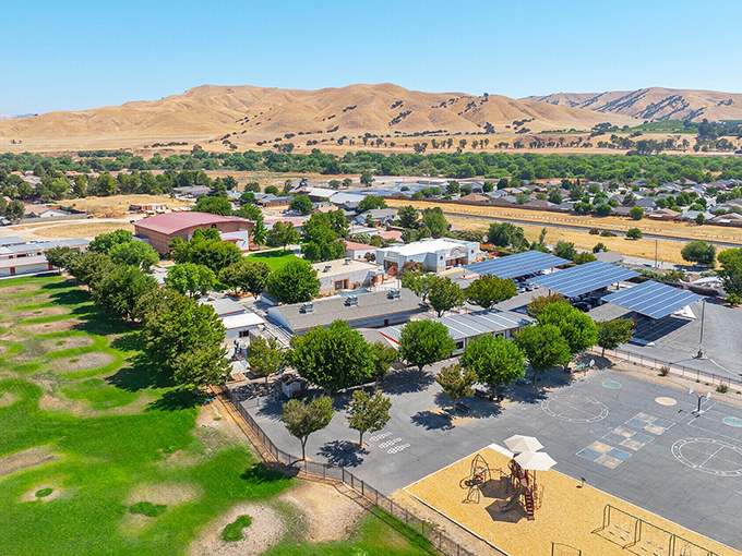 The town sits nestled among rolling hills that look like they were designed by an artist with a very generous brush.