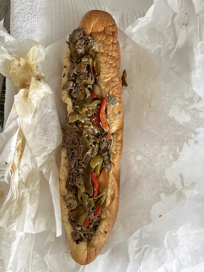This cheesesteak looks like it could feed a small village. The golden-brown roll cradles its precious cargo of beef, peppers, and onions.