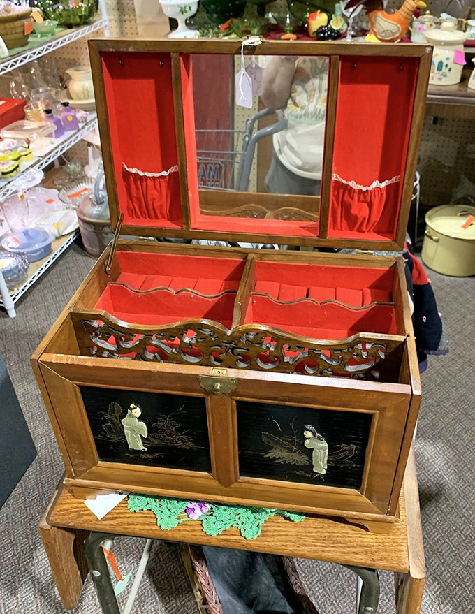 This ornate jewelry box with its vibrant red interior once held someone's precious treasures. Now it waits to become someone else's cherished find.