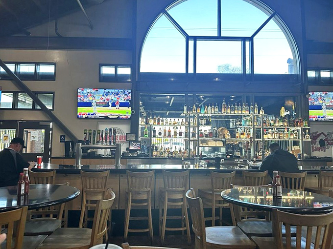 The polished bar area invites lingering conversations over cold drinks while kitchen magic happens behind the scenes.