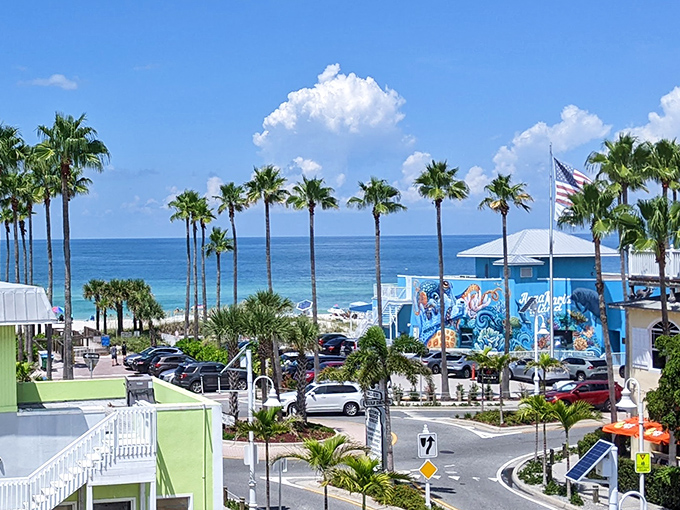 Palm trees frame the view like nature's exclamation points. The pastel buildings of the bay town look like they were designed by someone who really understands joy.